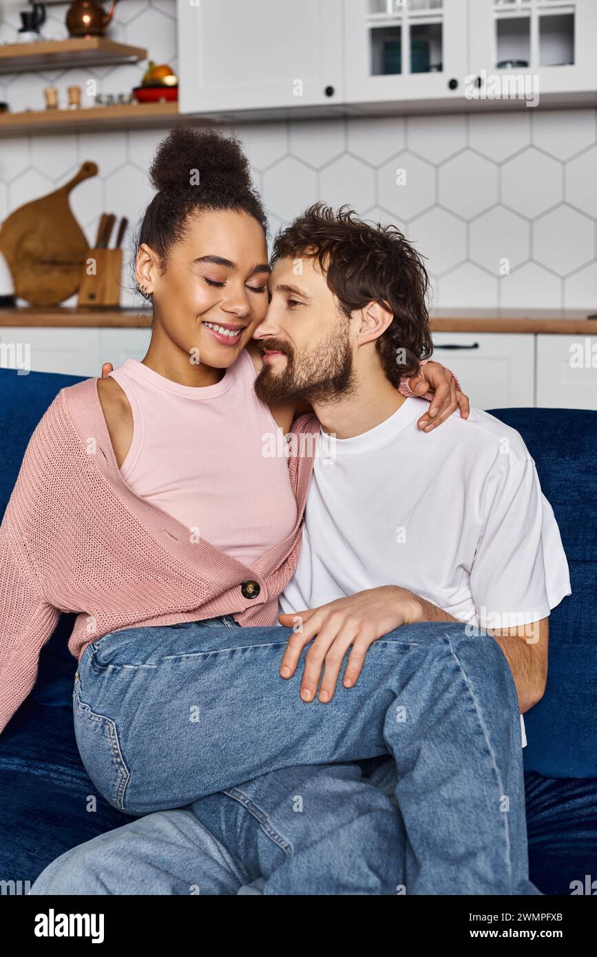 happy beautiful diverse couple in comfy attires sitting together on ...