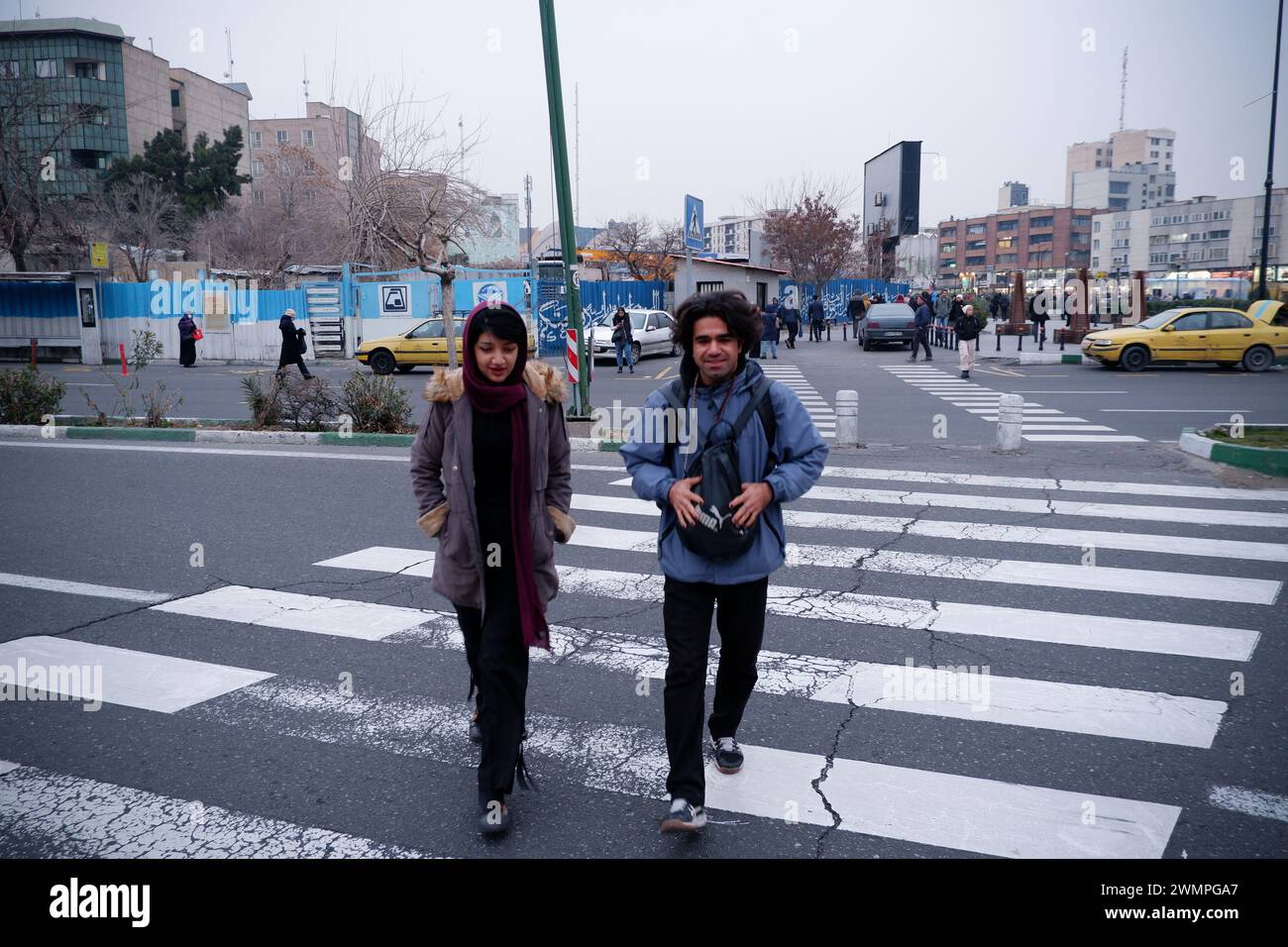 Tehran, Iran. 27th Feb, 2024. An Iranian couple crosses a street in ...