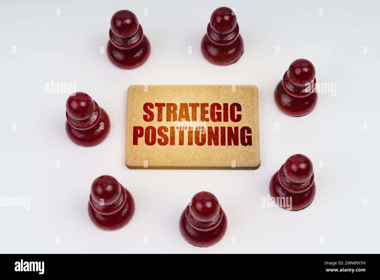 Business concept. On a white background, pawns stand around a sign with ...