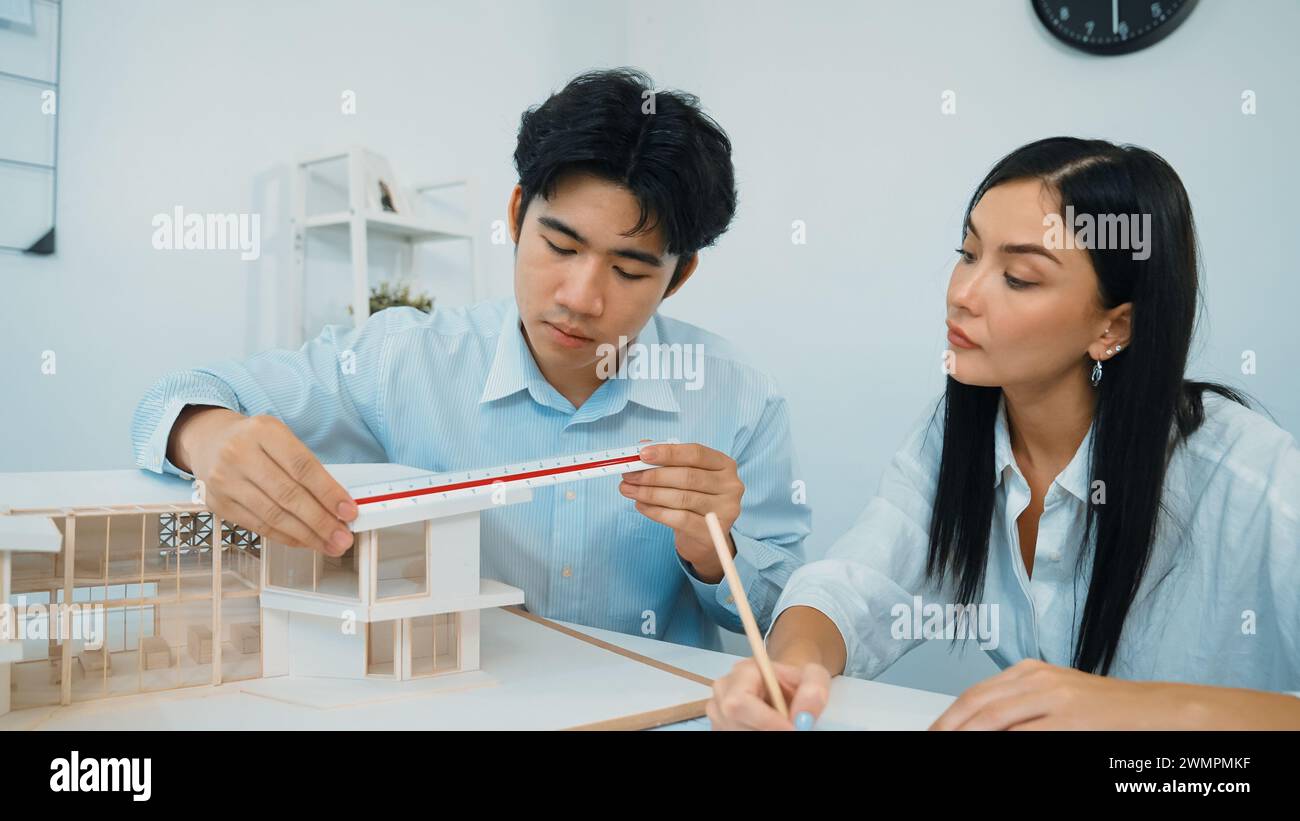 Professional male engineer measure house model by using ruler while ...