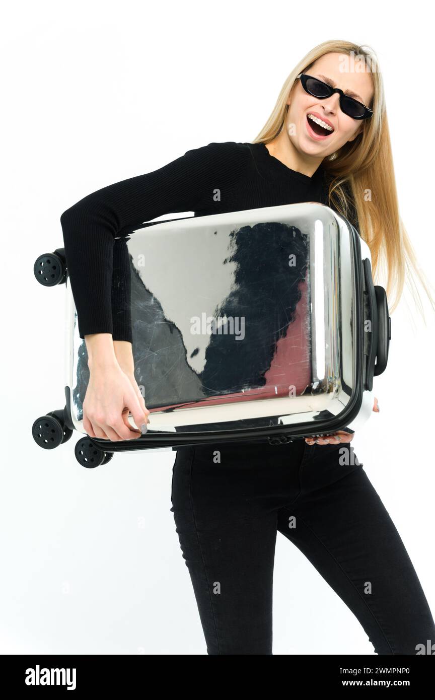 Pretty young woman with suitcase under her arm on white background ...