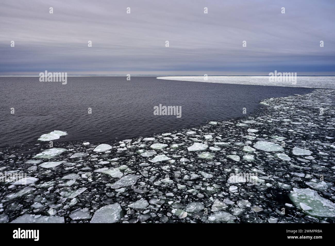 A vast body of water with floating ice chunks along its edge Stock ...