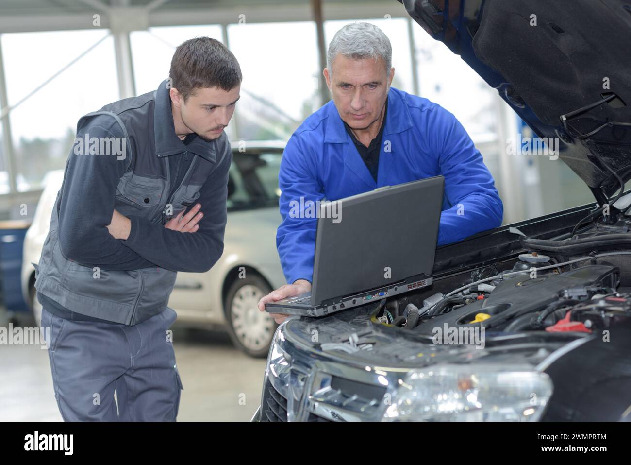 auto mechanic teacher and trainee performing tests at mechanic school ...