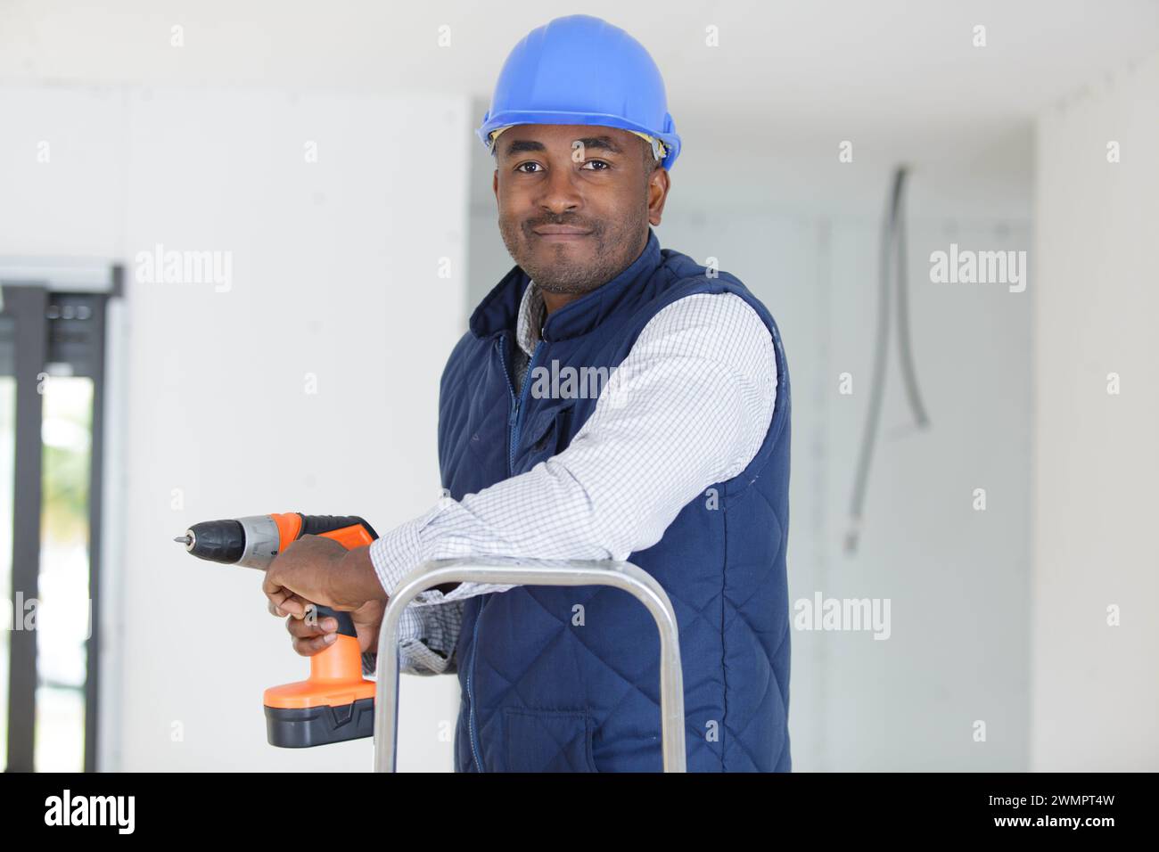 happy male builder standing on ladder Stock Photo - Alamy