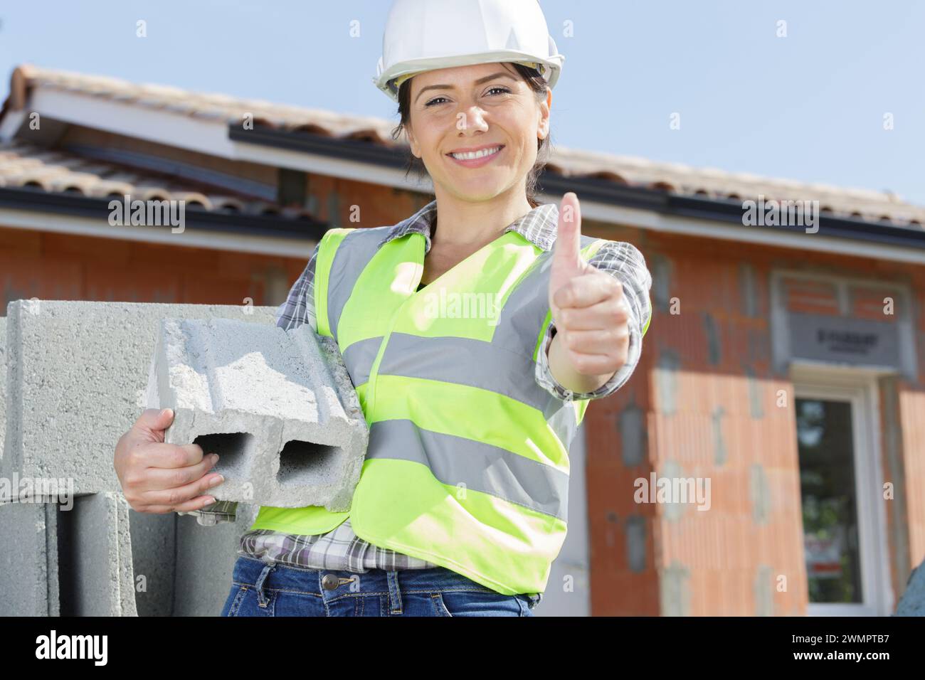 female construction worker carrying brick Stock Photo - Alamy