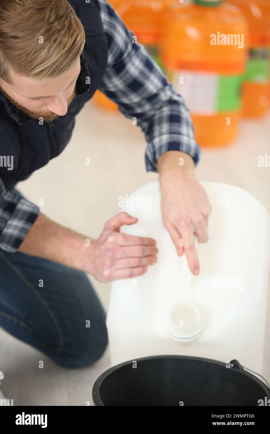 worker pouring industrial chemical into a bucket Stock Photo - Alamy