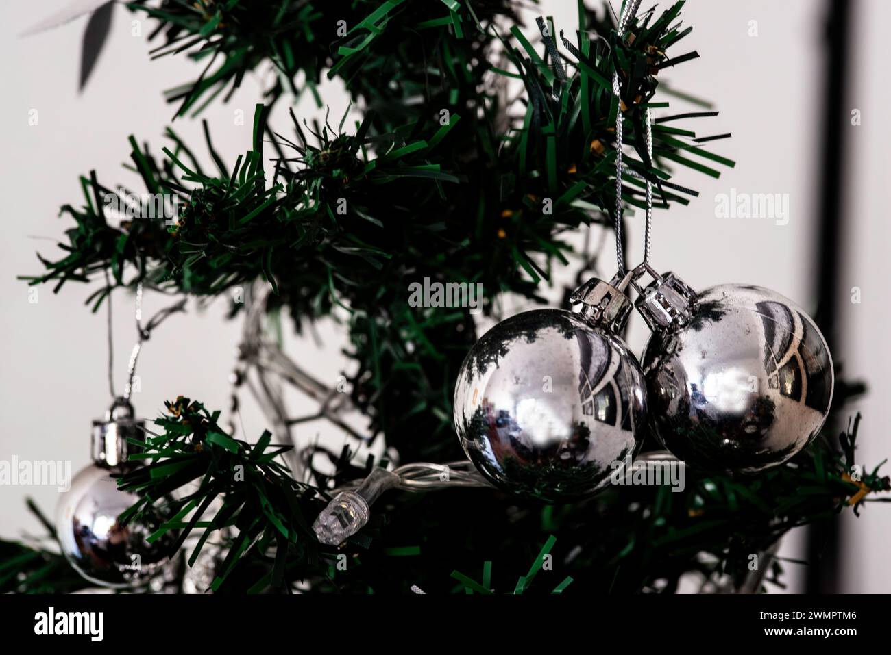 A cluster of gleaming decorations on a Christmas tree branch, with room ...