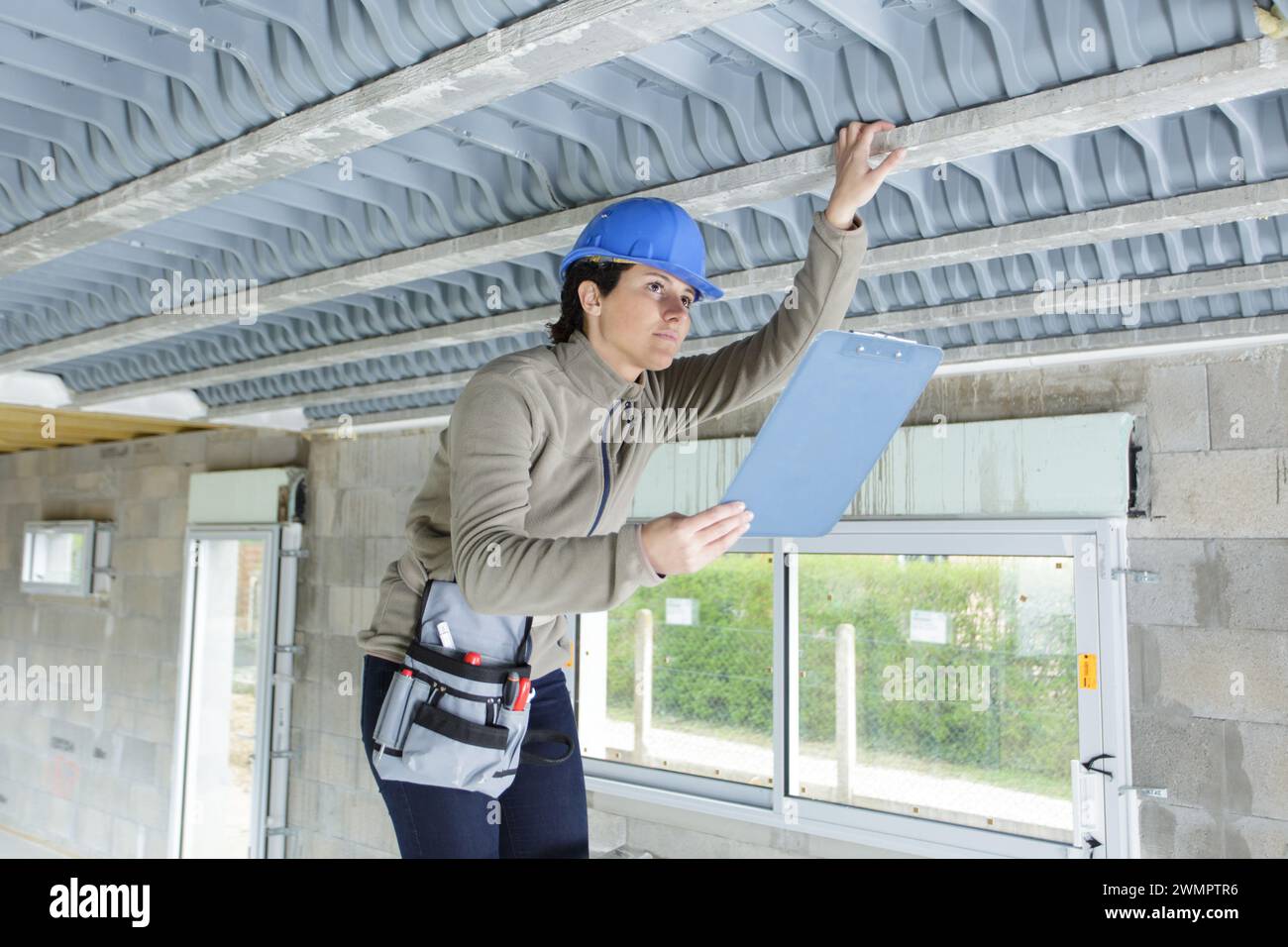 female builder checks beams on the ceiling Stock Photo - Alamy