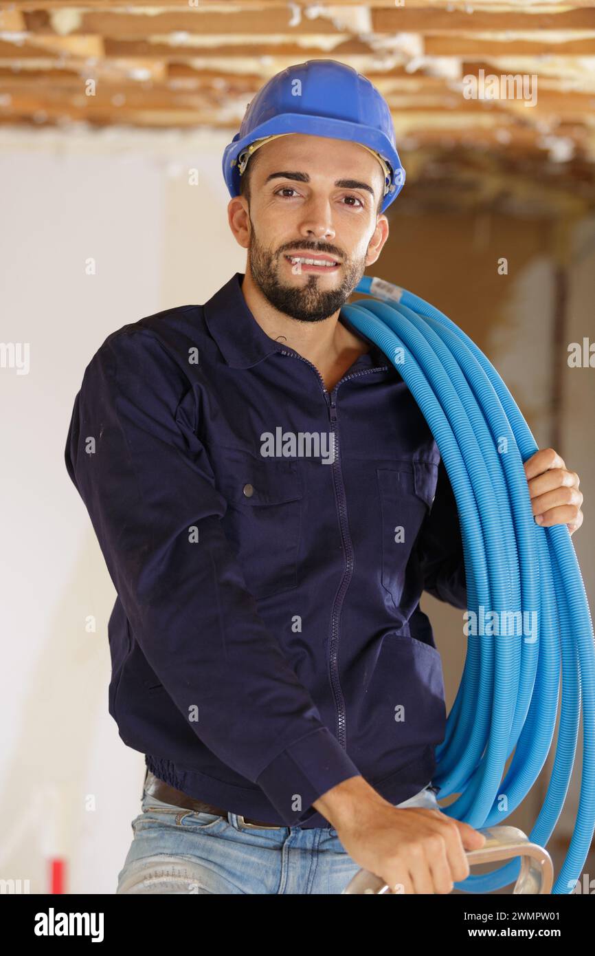 a male builder holding pipes Stock Photo - Alamy