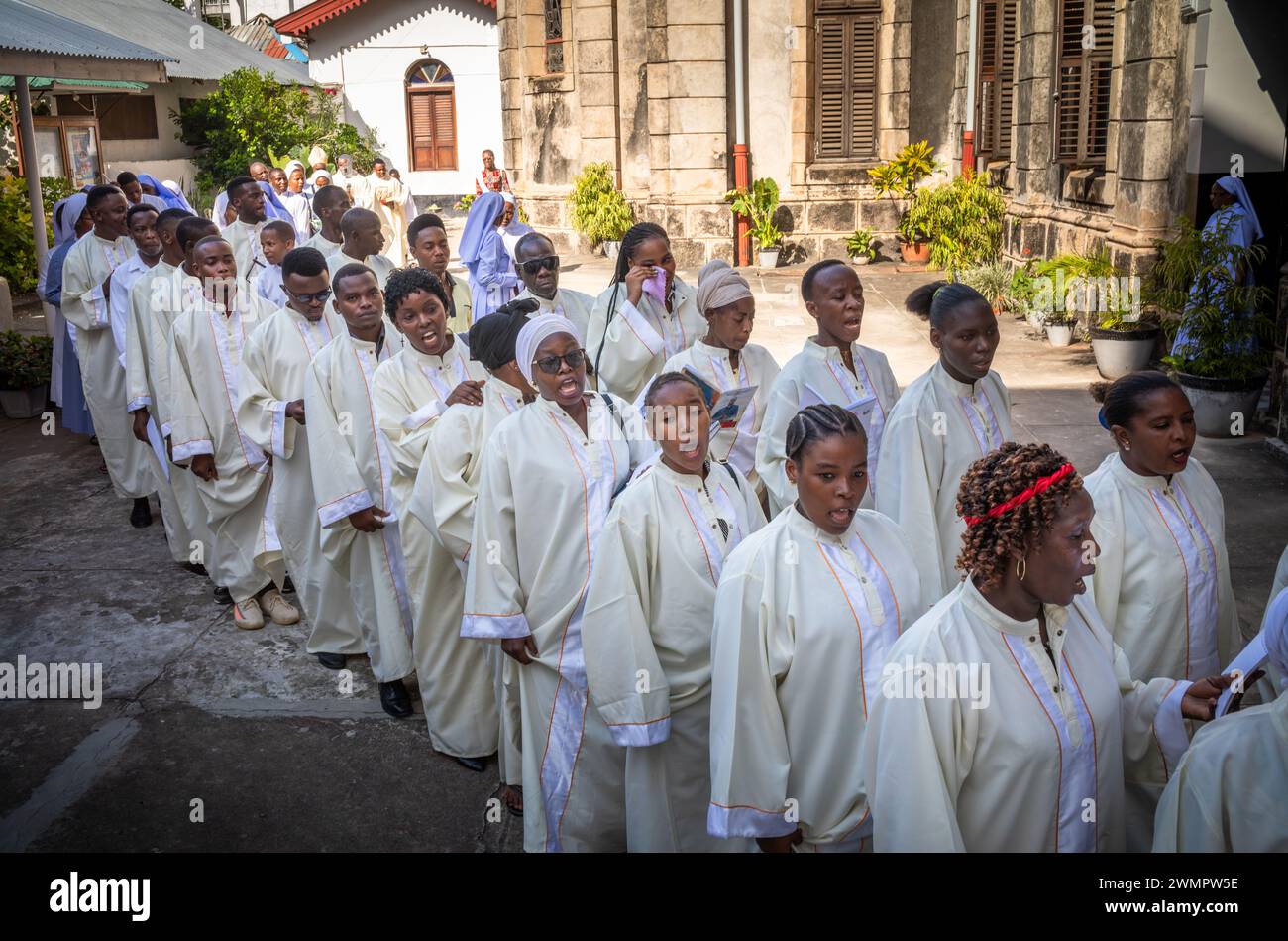 Dressed in white, the choir sings as it enters St Joseph's Cathedral ...