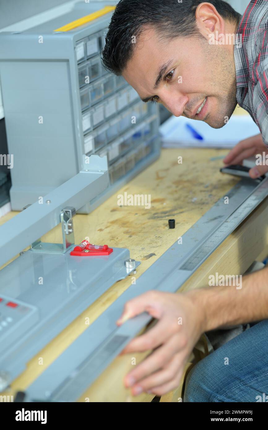 a male worker measuring workspace Stock Photo - Alamy