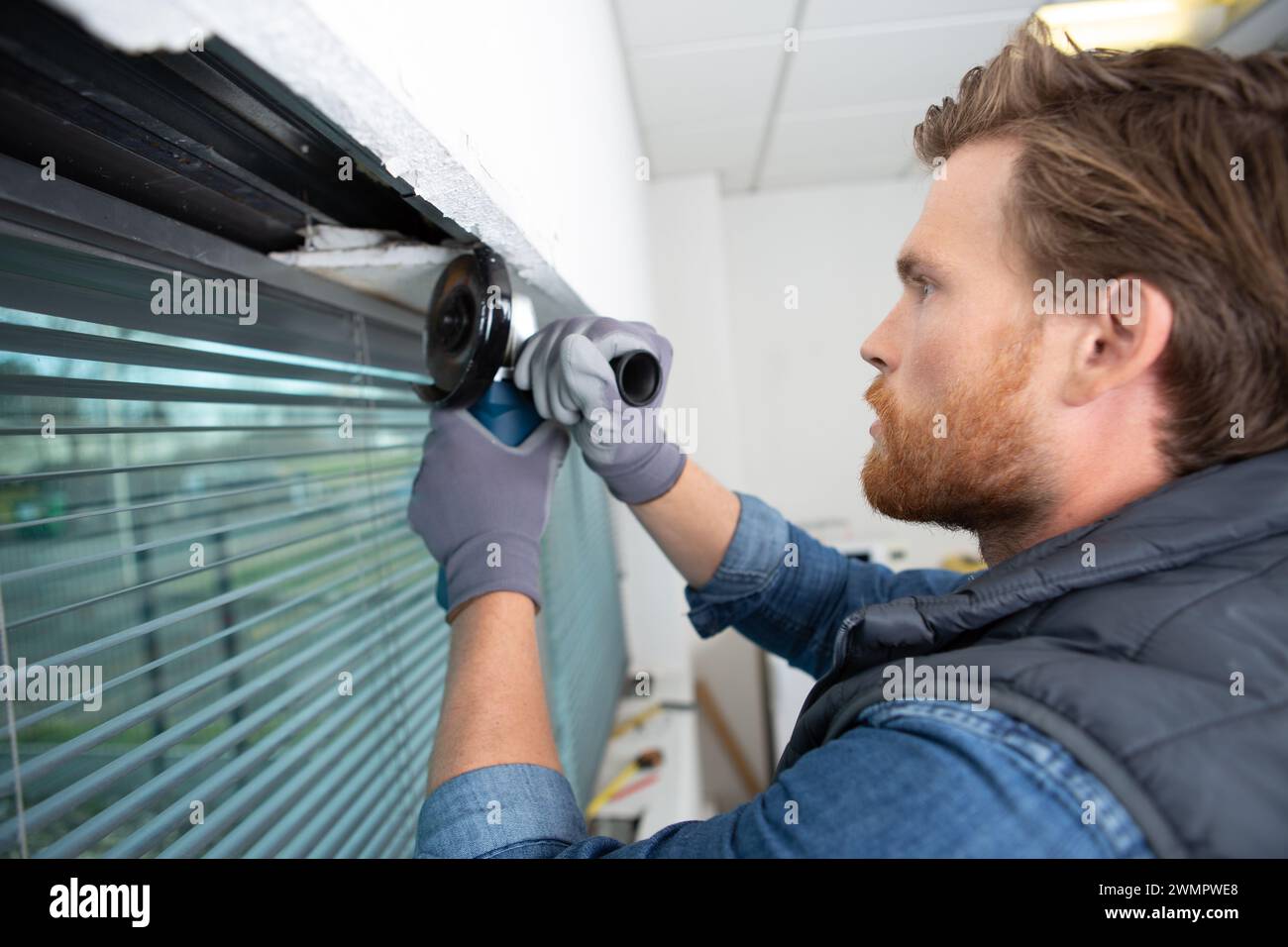 handyman cutting a circular hole into window Stock Photo - Alamy