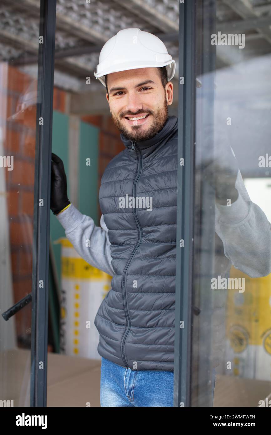 handsome young man installing bay window Stock Photo - Alamy