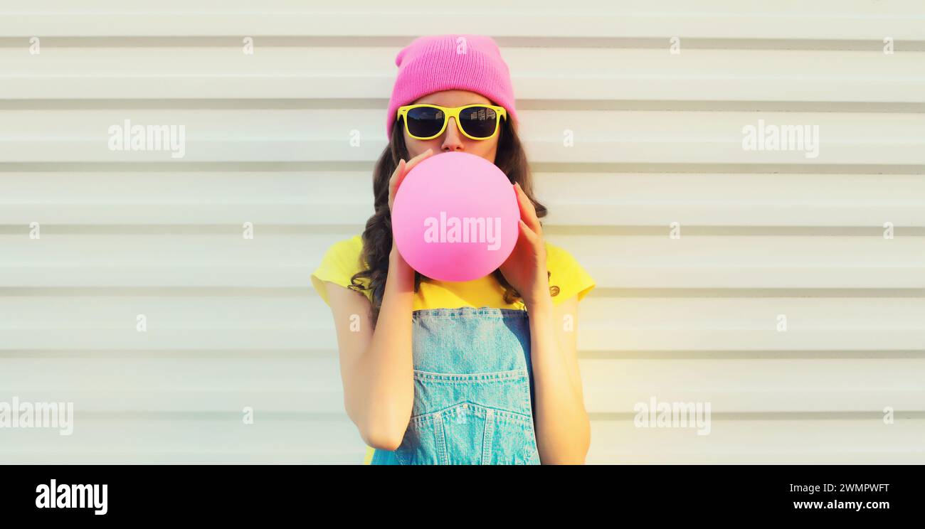 Fashion portrait of stylish cool young woman inflating chewing gum or ...