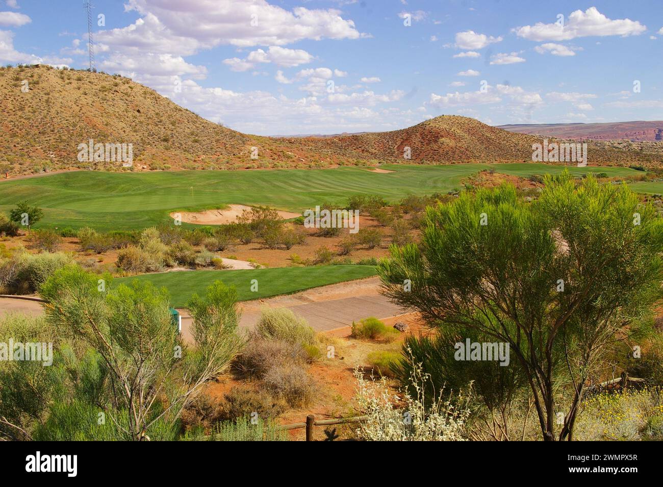 A scenic view from hilltop of golf course, mountains, and clear blue ...