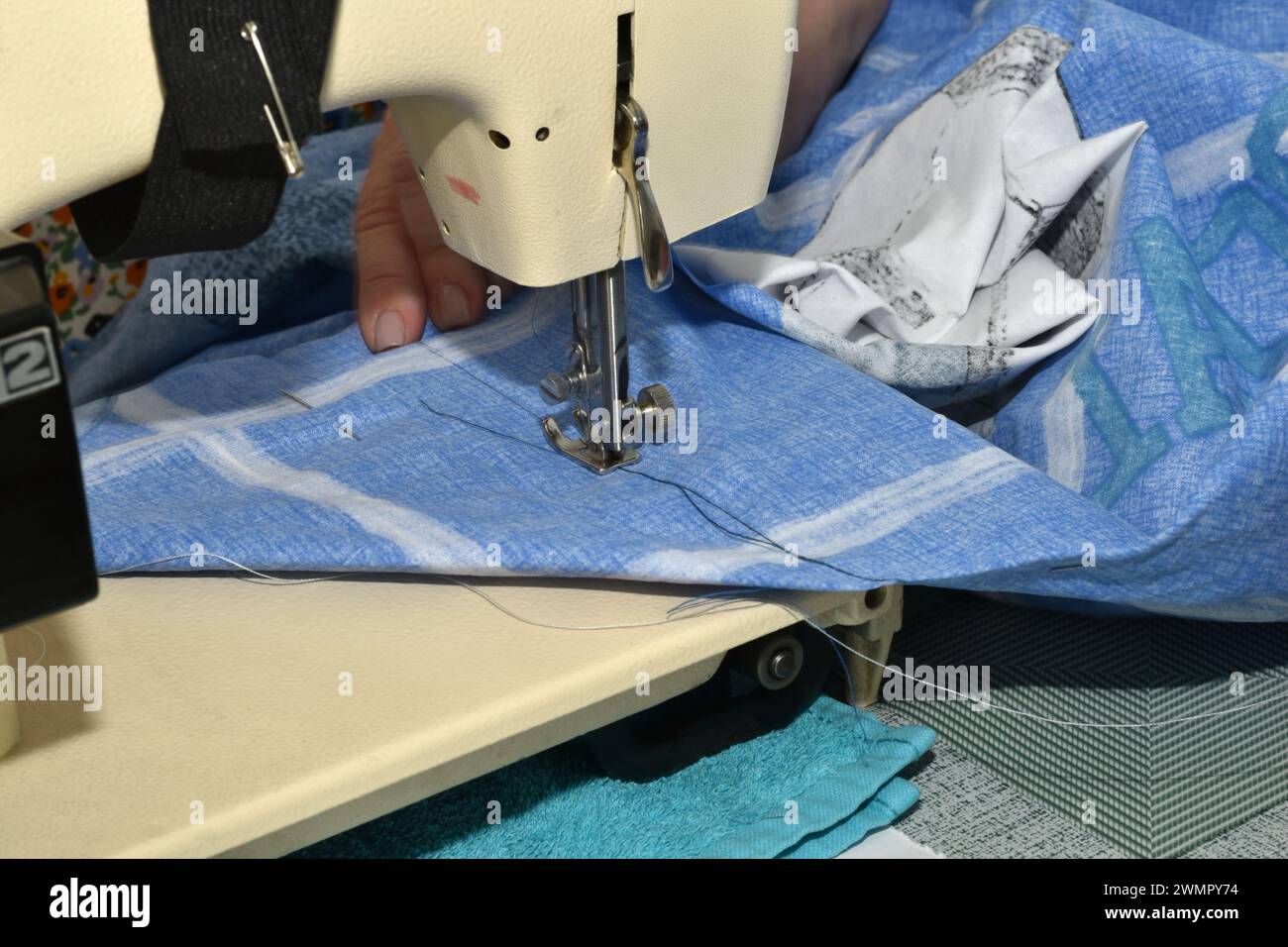 On the subject table with a sewing machine, under the needle is a blue ...