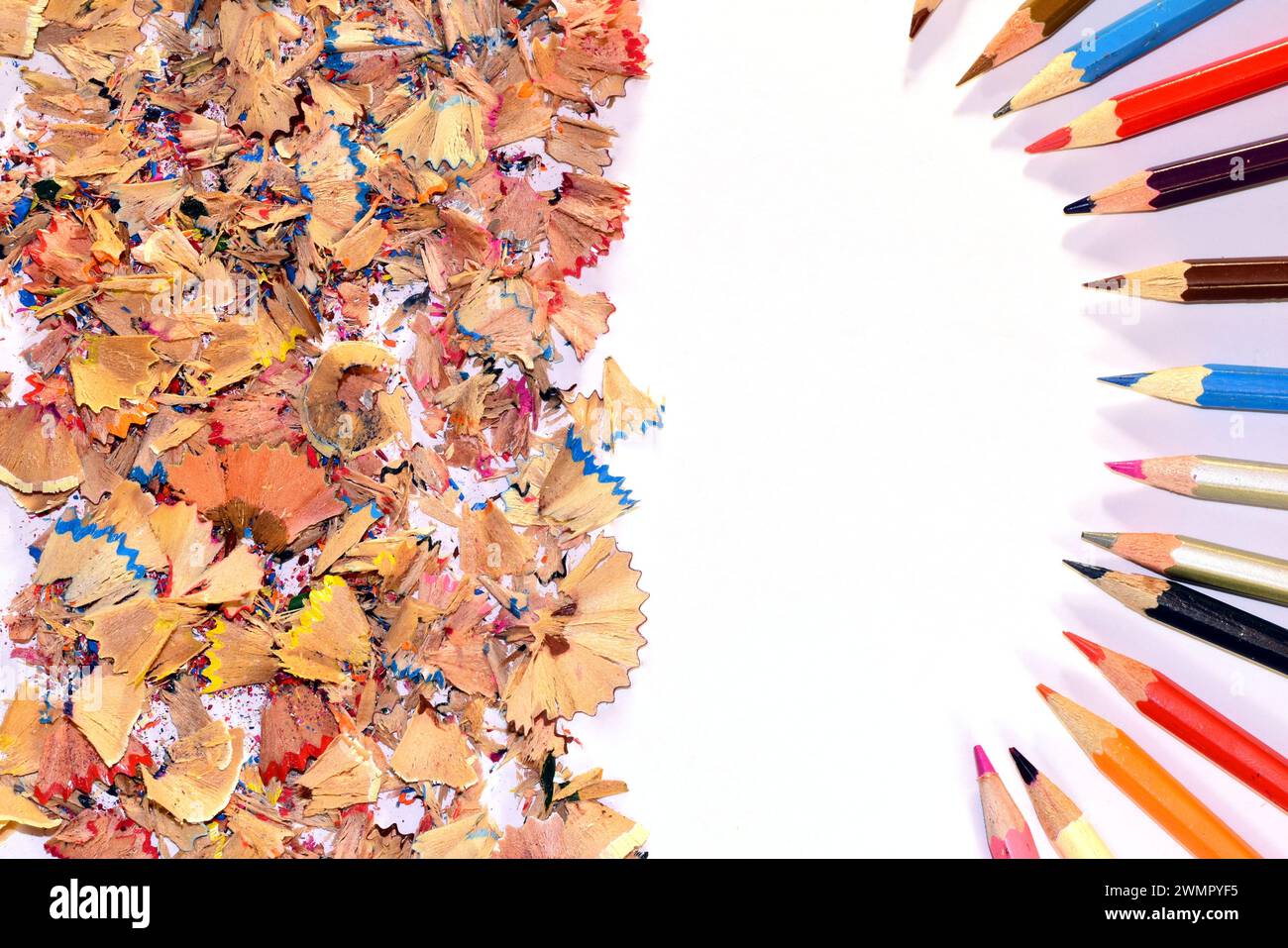 On the table lie sharpened colored pencils, wood shavings from them ...