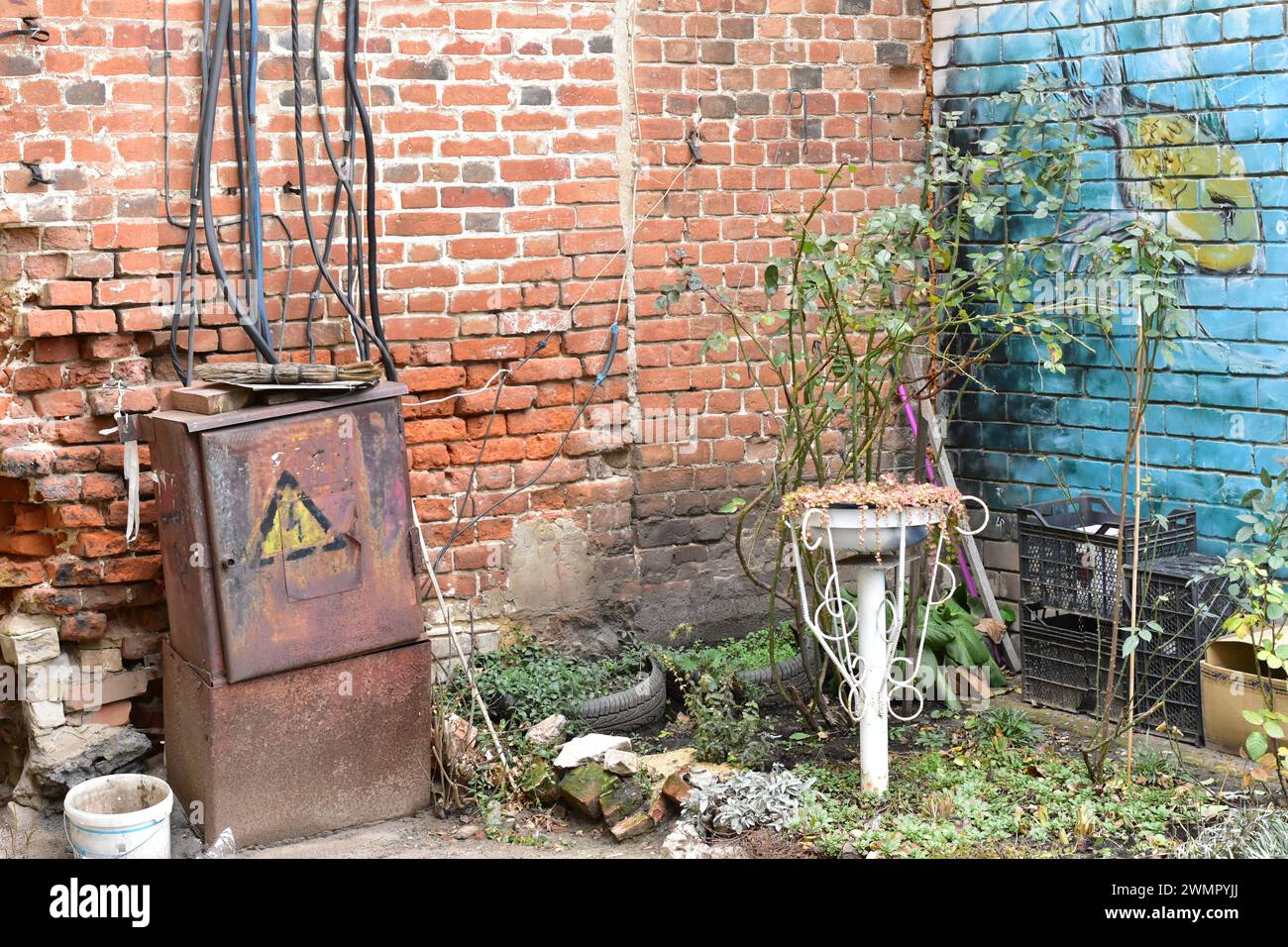 The picture shows a corner created by two red brick stone walls and a ...