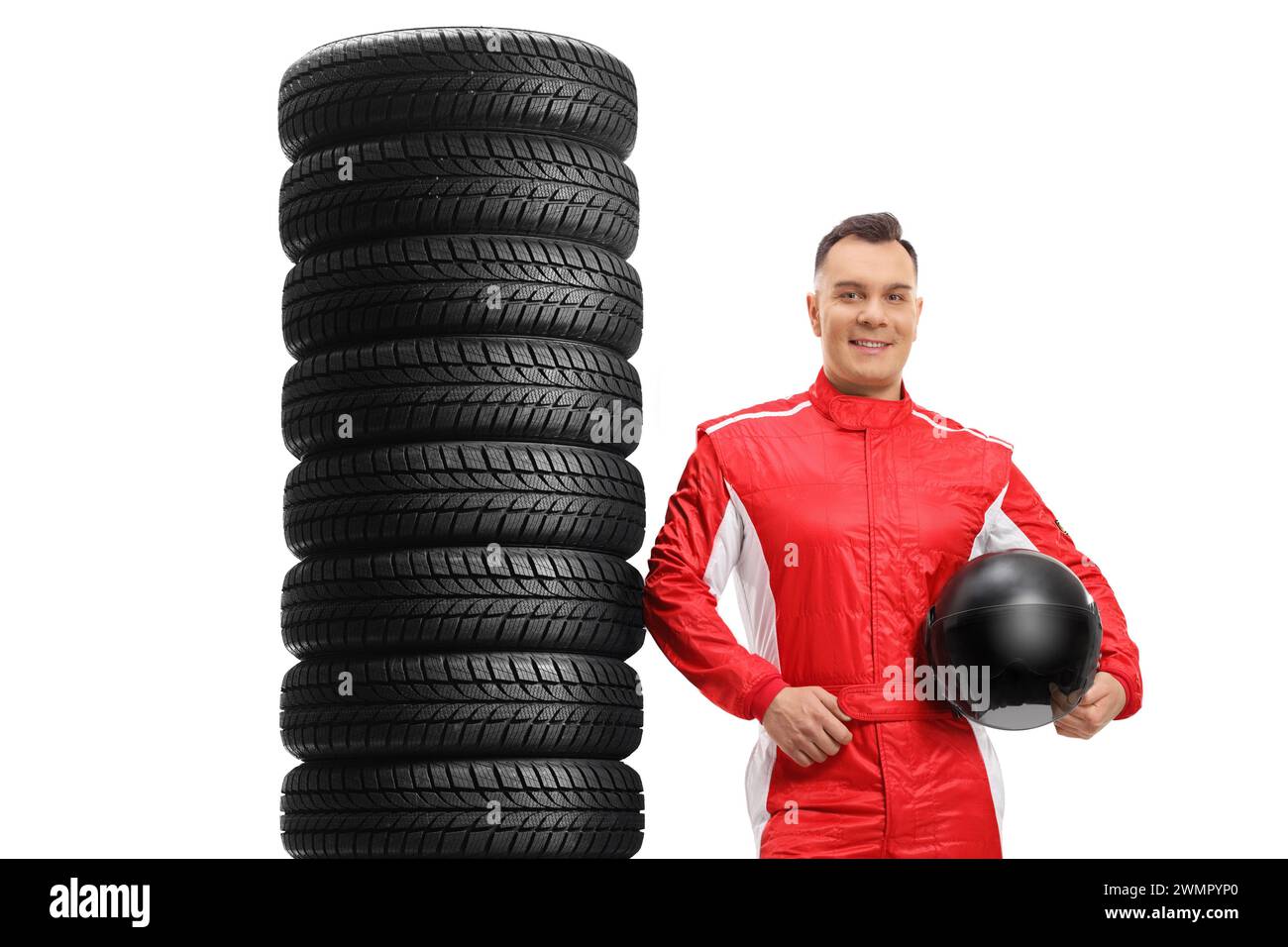 Racer leaning on a pile of tires and holding a helmet isolated on white ...
