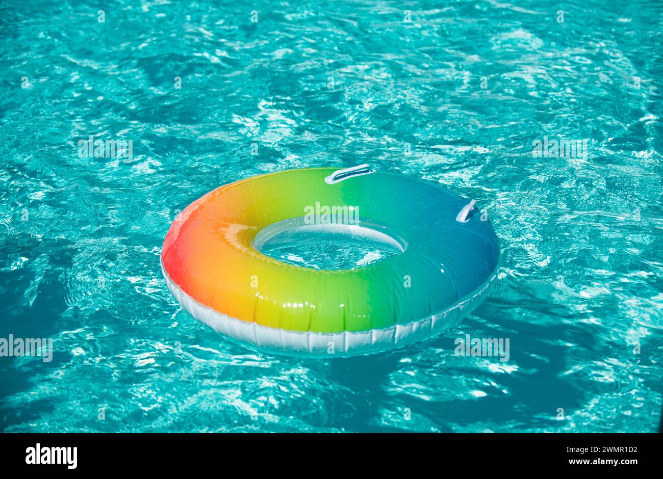 Inflatable ring floating in pool on summer background. Rainbow swimming ...