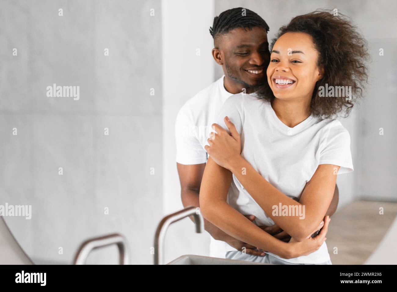 African American couple shares embrace during morning routine in ...