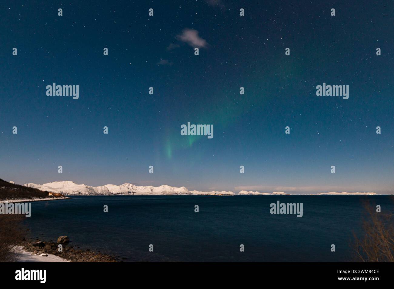 Aurora borealis over snow-capped mountains in kvæfjordjor in the ...