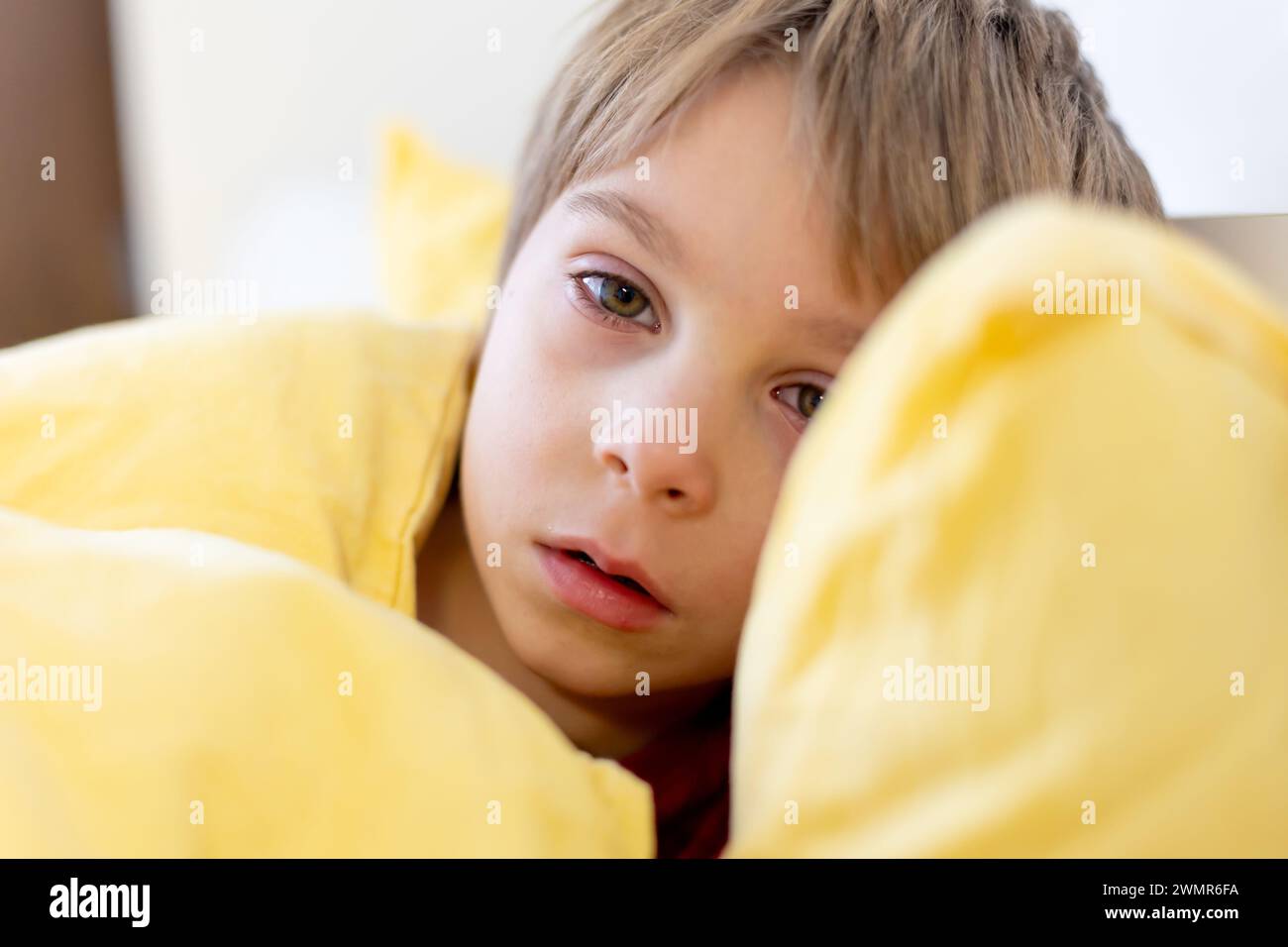 Sick child, toddler boy lying in bed with a fever, having breakfast ...