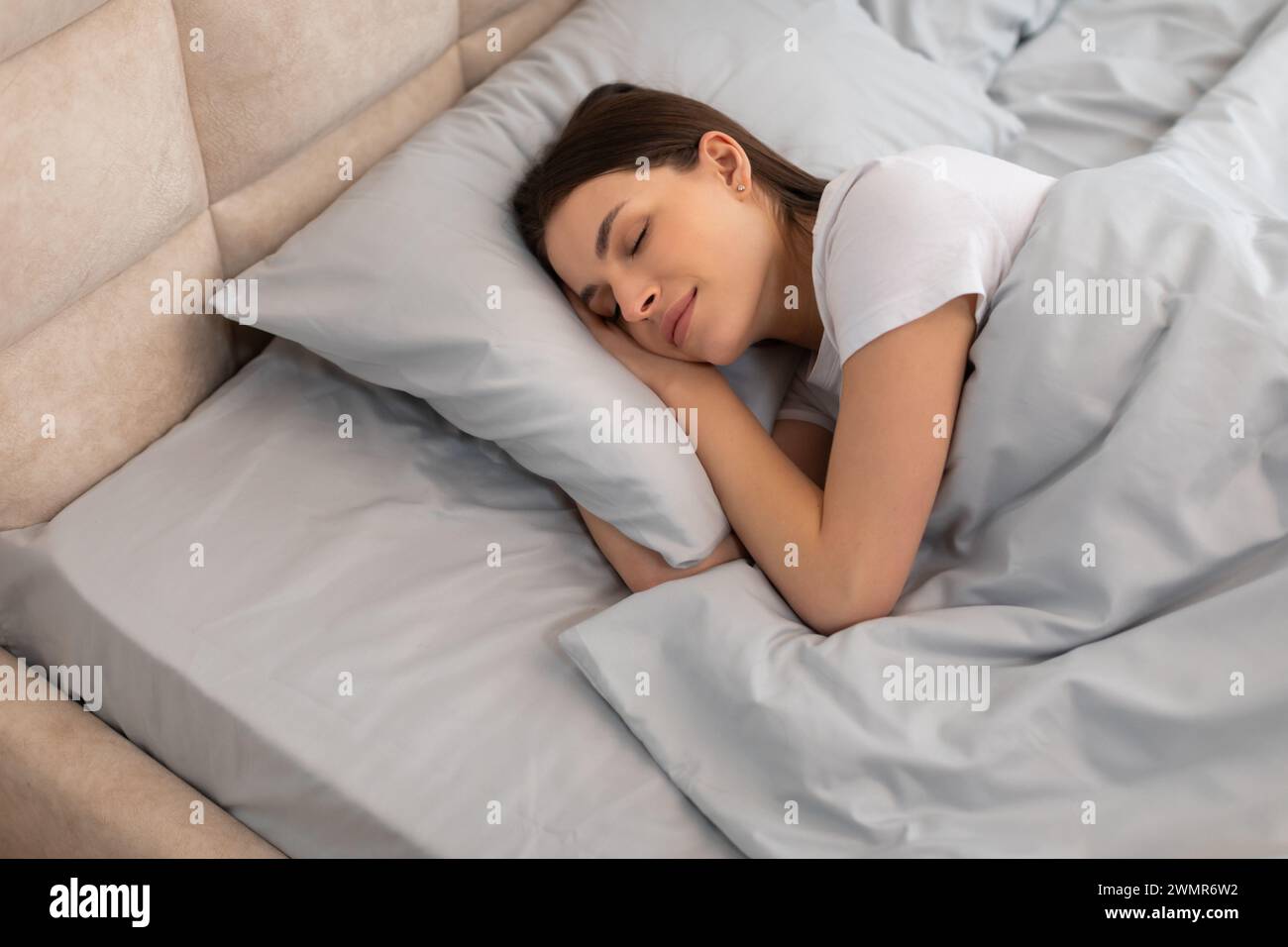 Woman sleeping peacefully bed white bedding hi-res stock photography ...