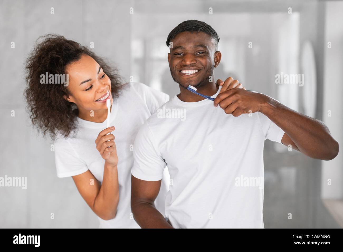 Loving married african american couple brushes teeth together in ...