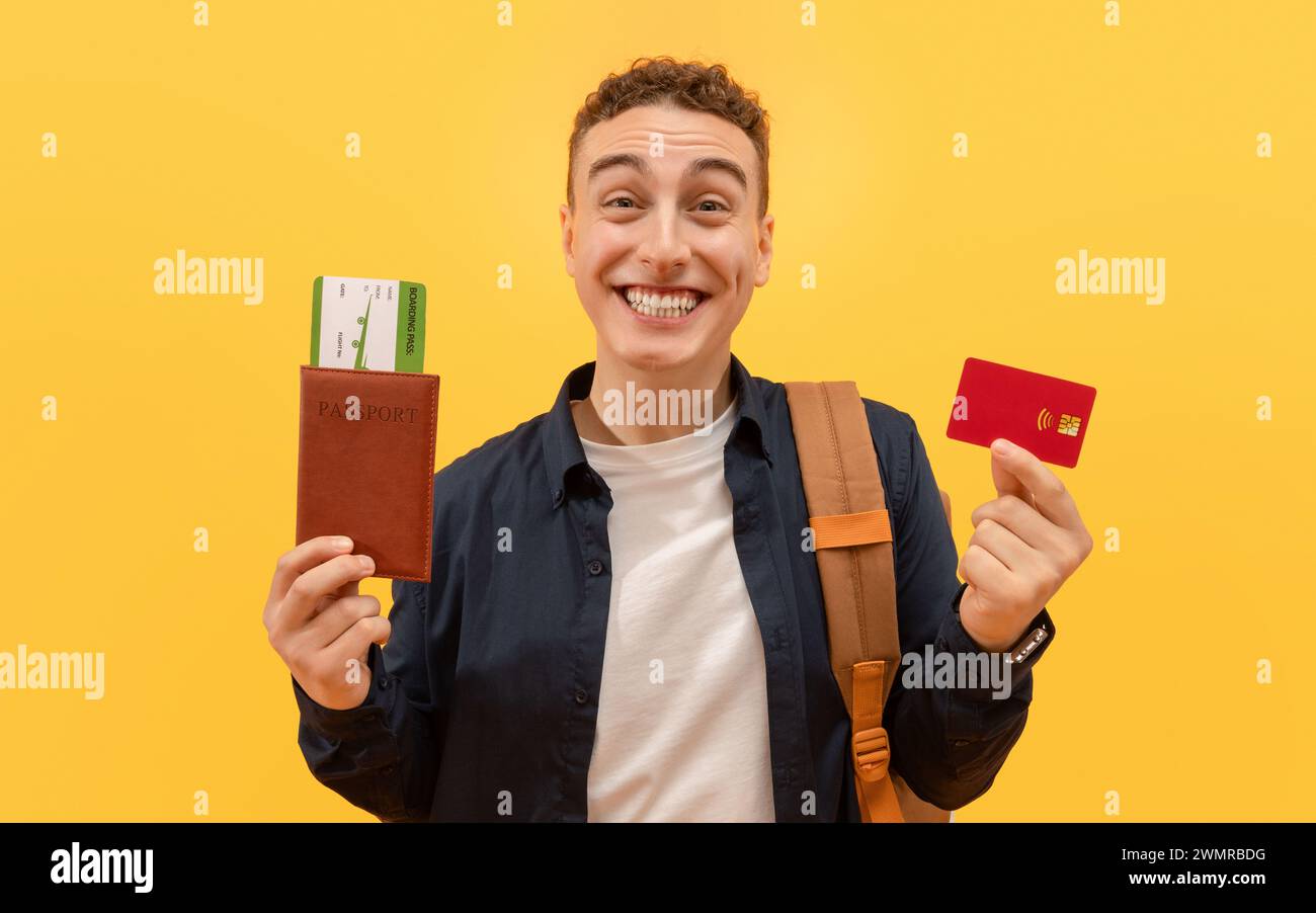 Emotional young guy showing tickets and credit card Stock Photo - Alamy