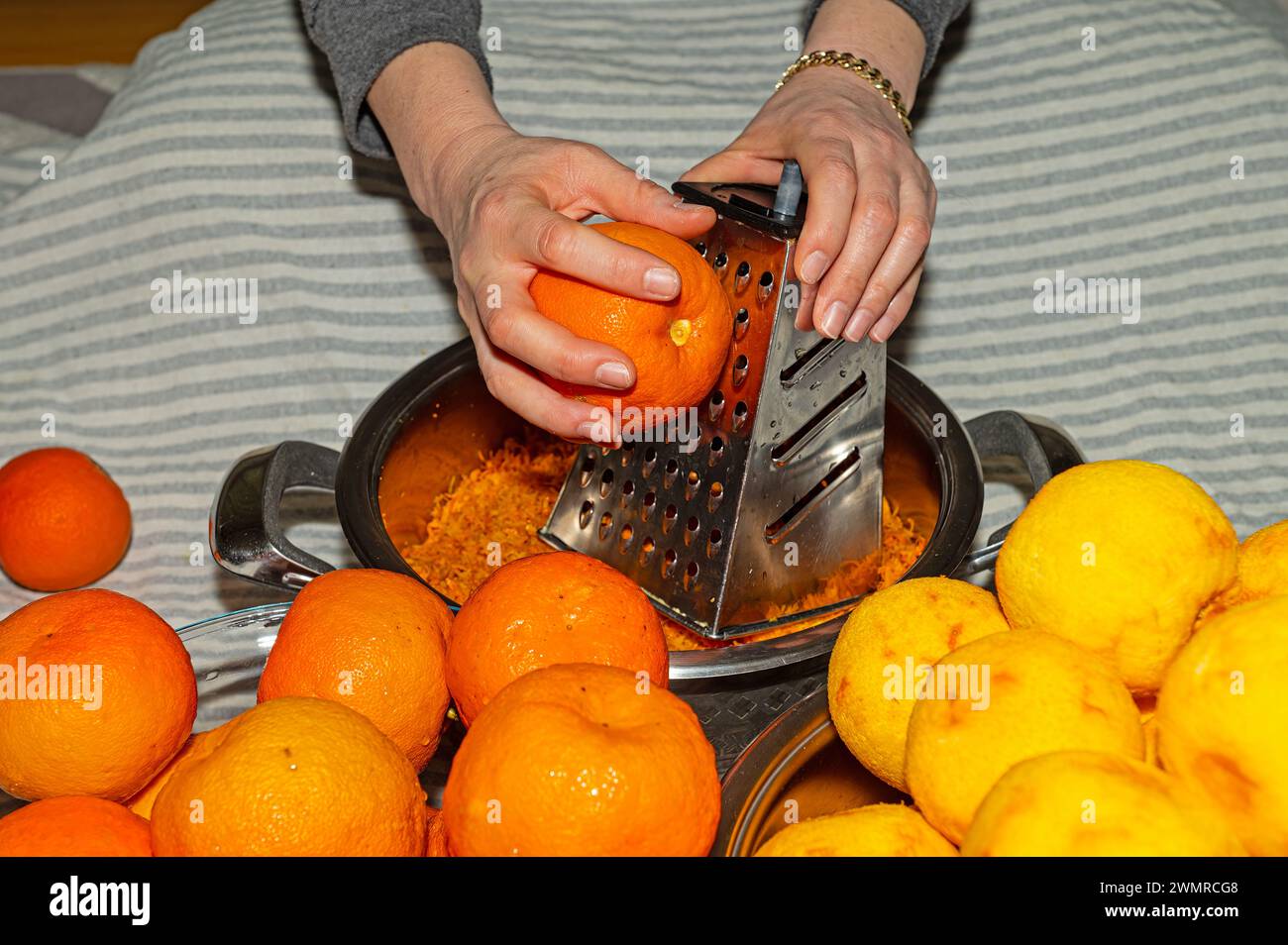 The woman grates the rind of citrus fruits to make jam Stock Photo - Alamy