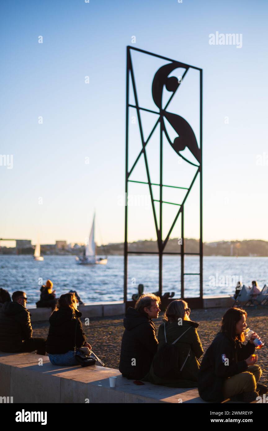 People enjoying the sunset on Ribeira das Naus, the riverfront ...