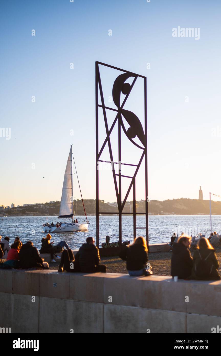 People enjoying the sunset on Ribeira das Naus, the riverfront ...