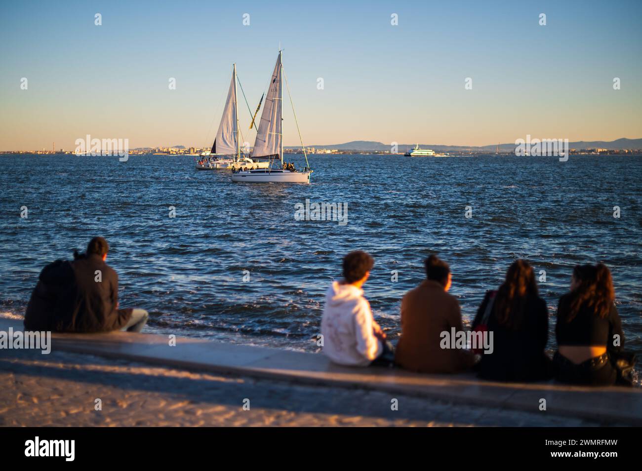 People enjoying Ribeira das Naus, the riverfront promenade and urban ...