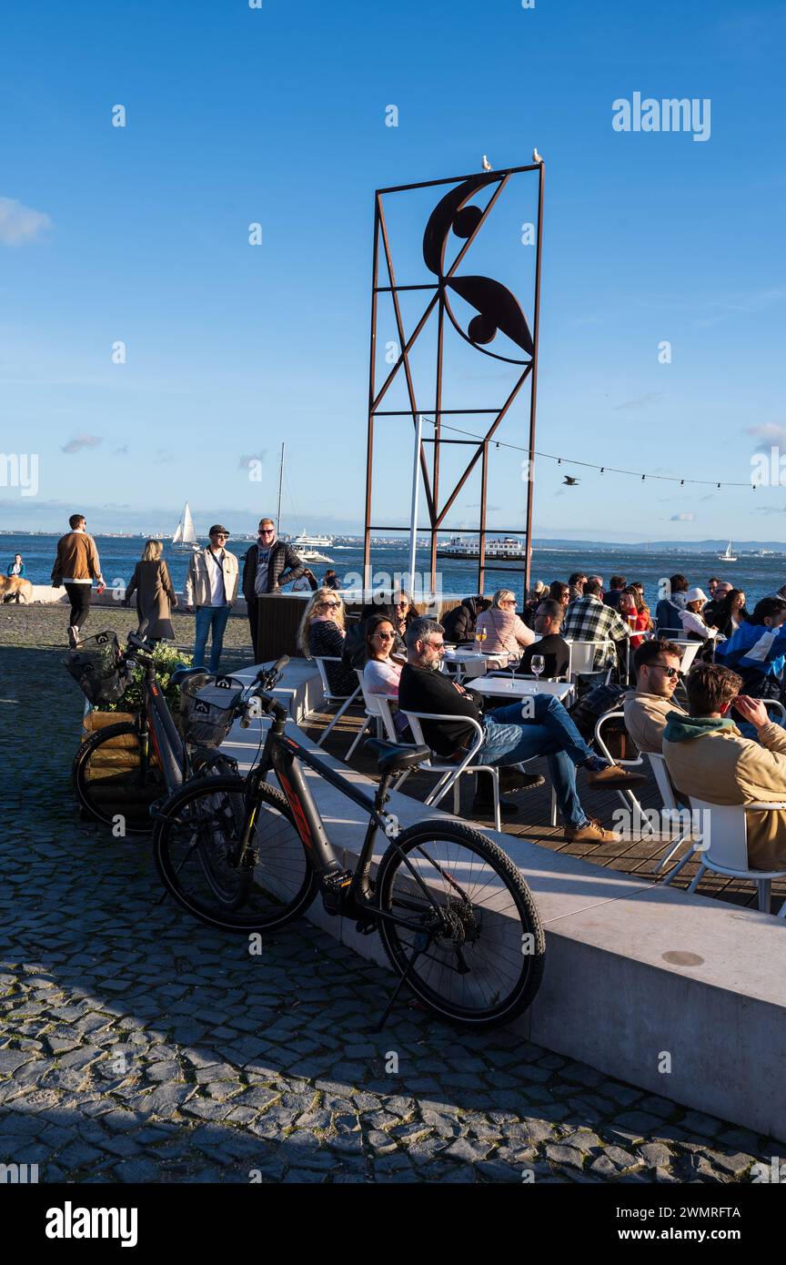People enjoying the sunset on Ribeira das Naus, the riverfront ...
