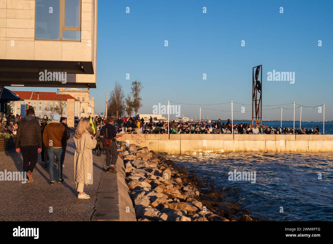 People enjoying Ribeira das Naus, the riverfront promenade and urban ...