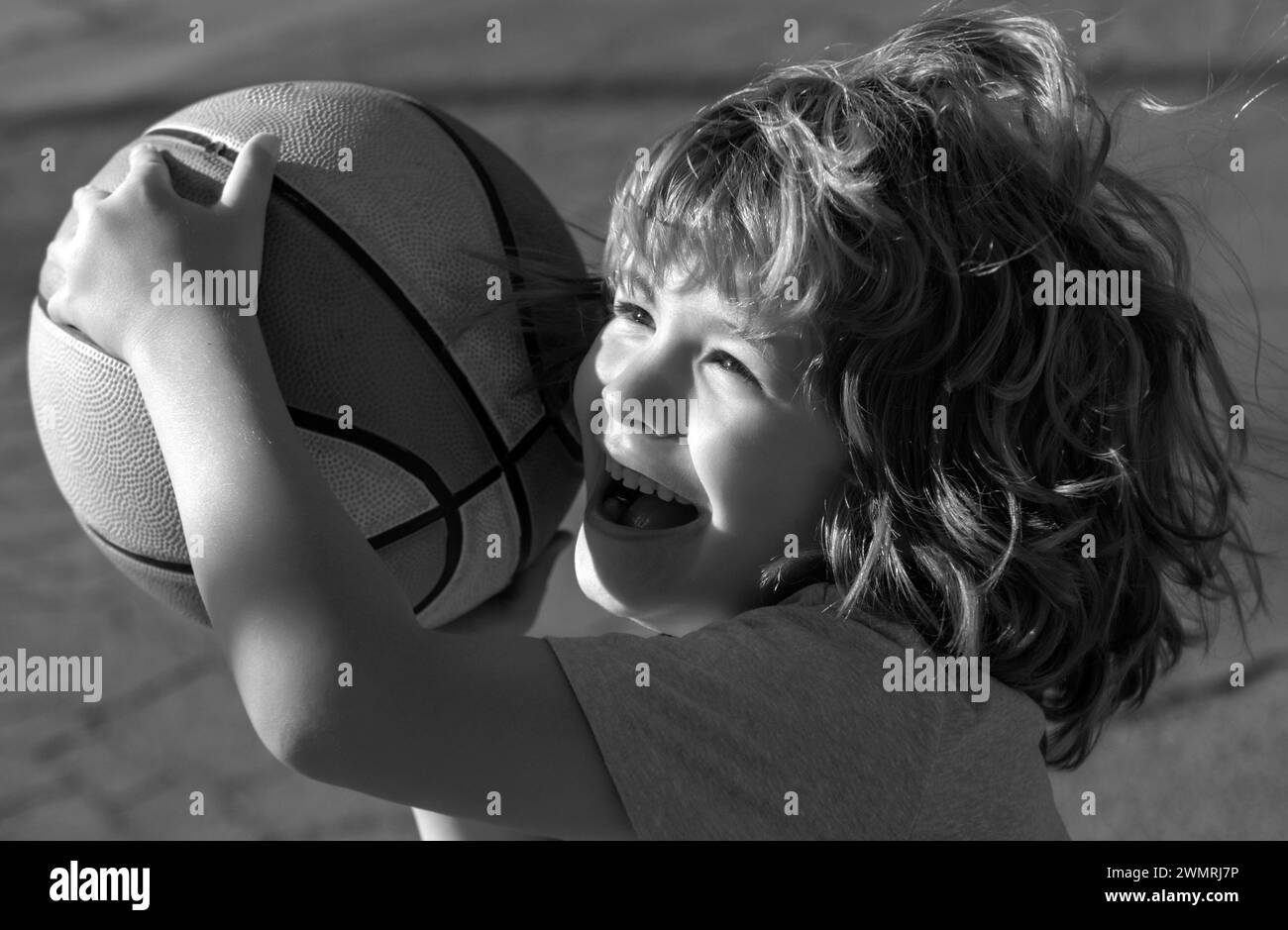 Cute smiling excited boy plays basketball. Funny child face closeup ...