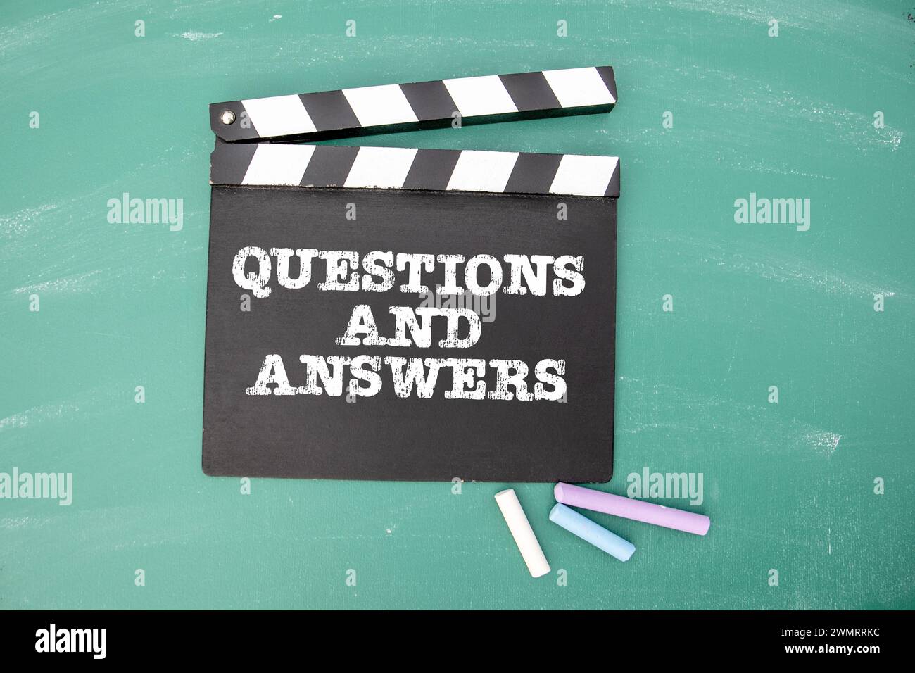 Questions and Answers. Movie clapper and colored pieces of chalk Stock ...