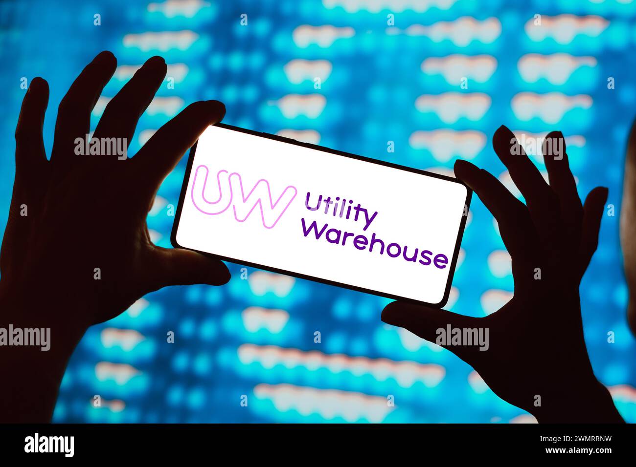 In this photo illustration, the Utility Warehouse (UW) logo is ...