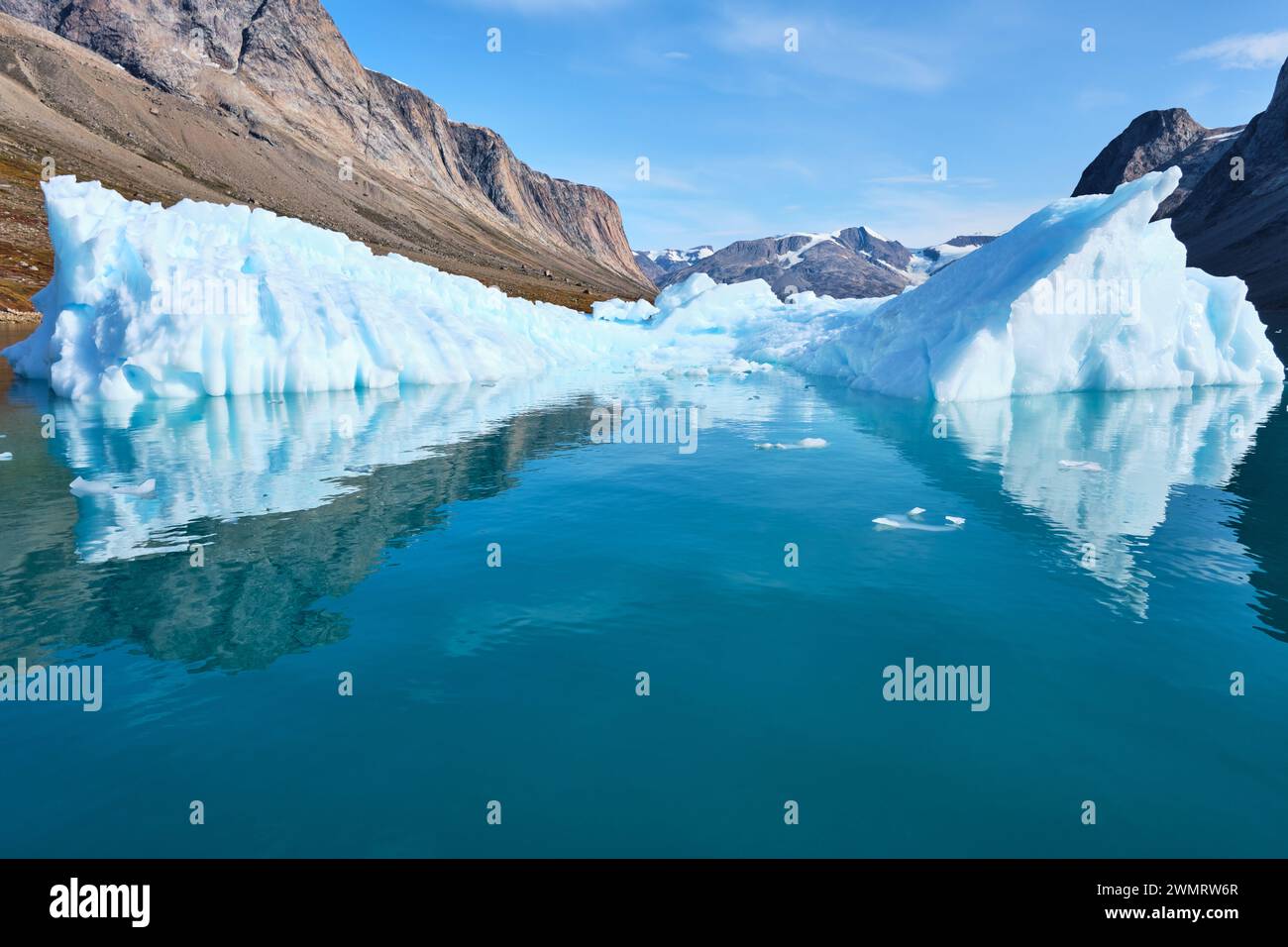 Calm, turquoise reflections of two-sided iceberg floating in the fjord ...