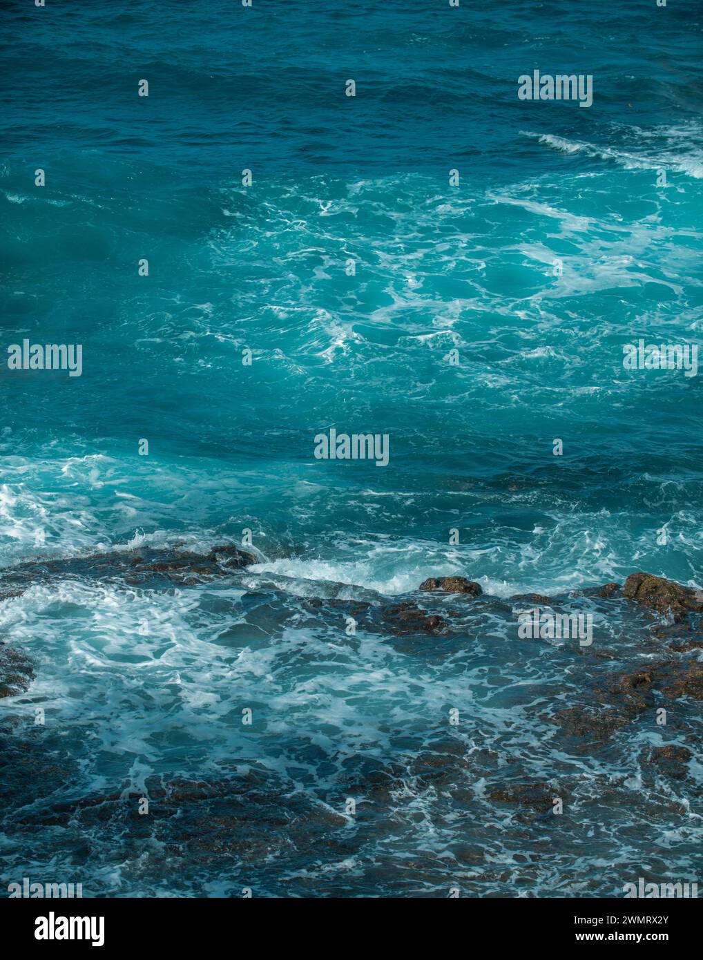Cooled black lava beaten by the Atlantic ocean waves. View of sea waves ...