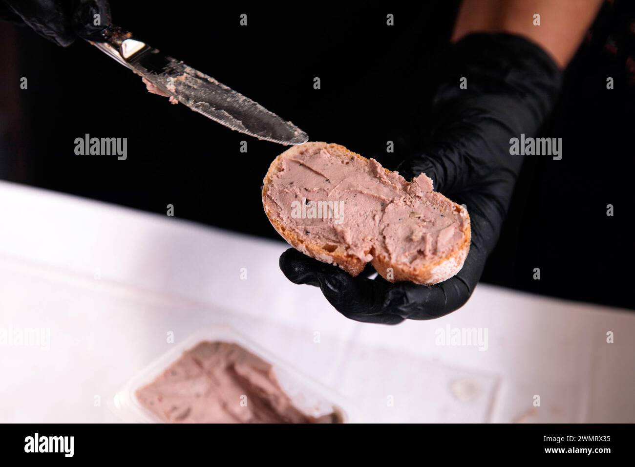 Hands with gloves spreading pâté on toasted bread slices Stock Photo ...