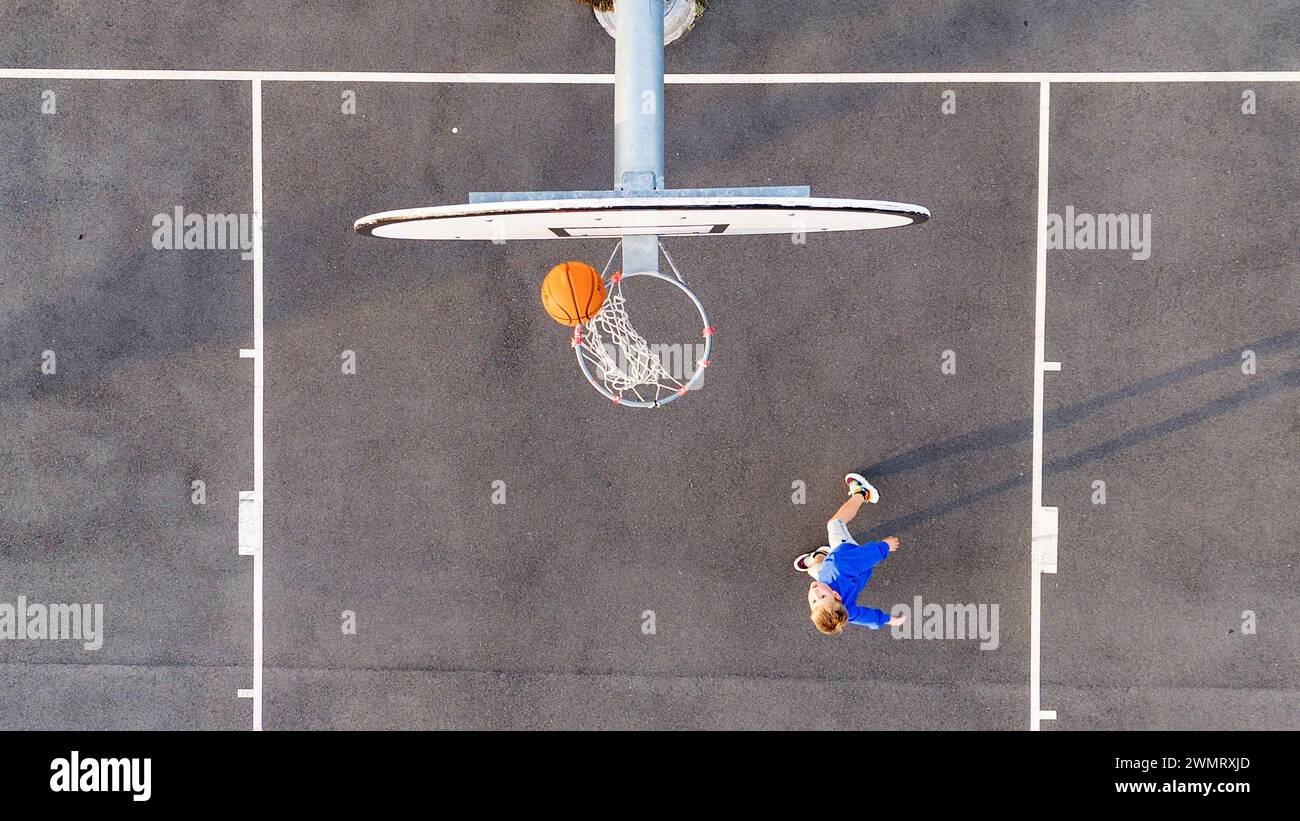 Street basketball. A bird's-eye view of a boy playing basketball on an ...