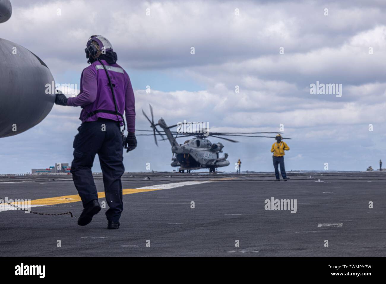 A U.S. Navy Sailor directs CH-53E Super Stallion helicopters with ...