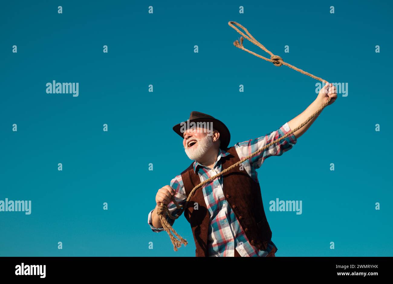 Lasso throwing. Old wild west cowboy with rope. Bearded western man ...