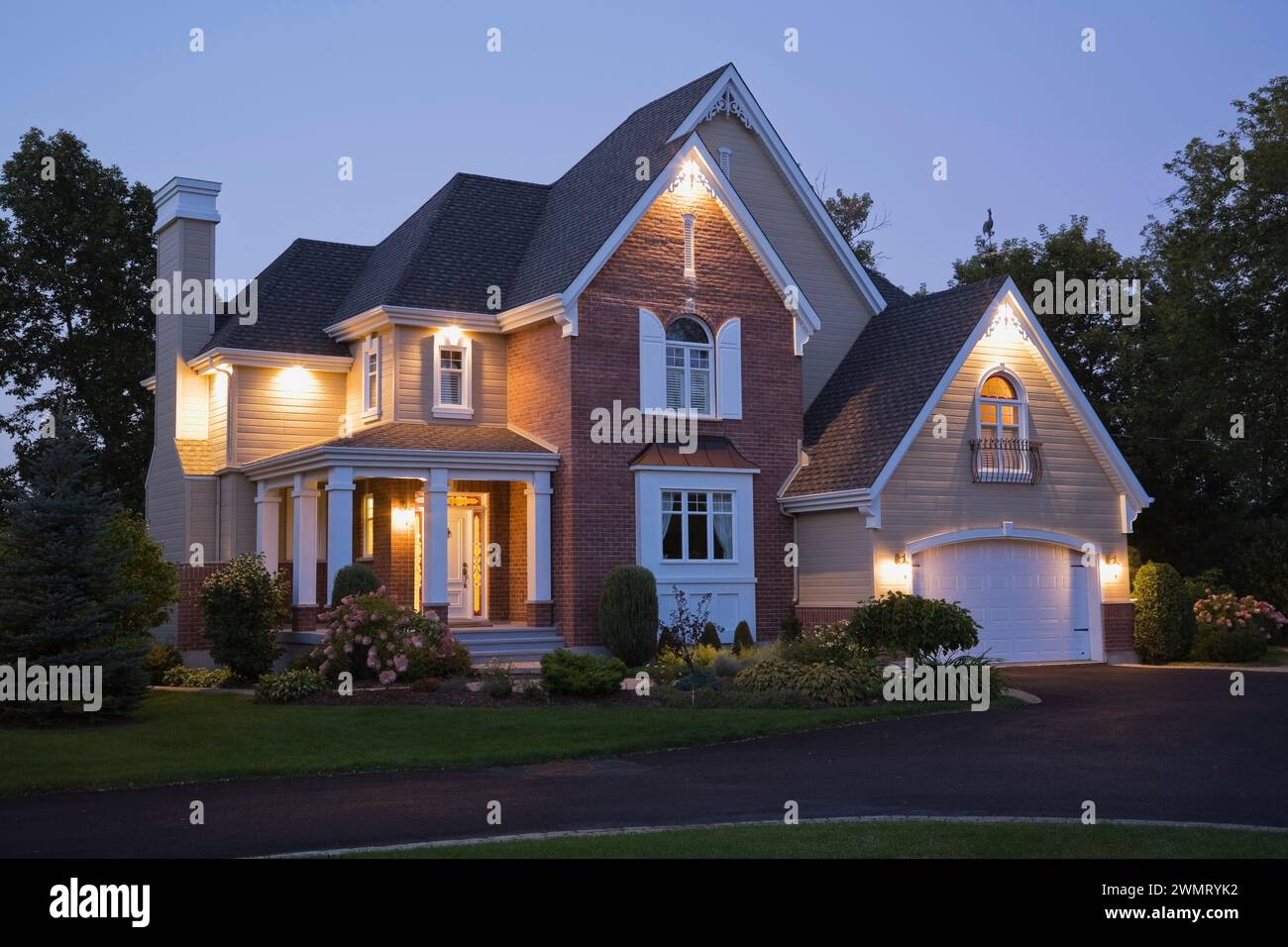 Two story red brick and tan clapboard cladded home with white trim ...