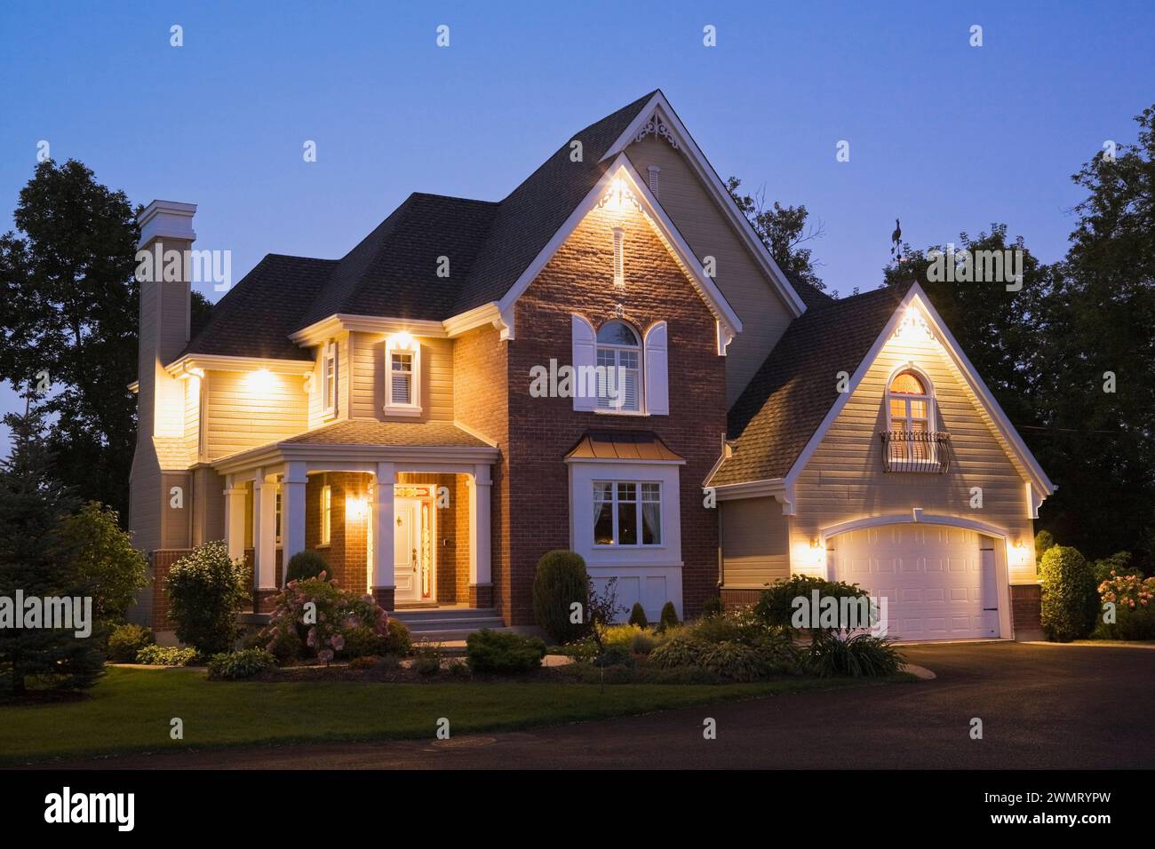 Two story red brick and tan clapboard cladded home with white trim ...
