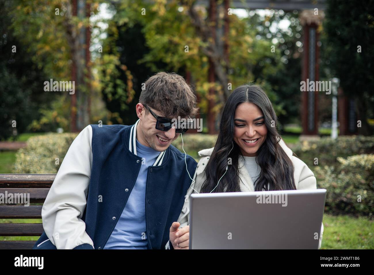 couple of students latin girl and caucasian boy with computer and ...