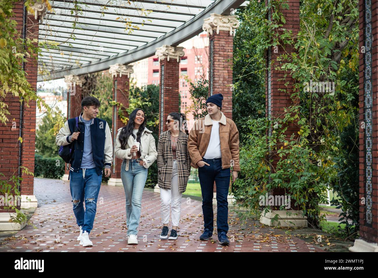 group of four multicultural college friends walking back from ...