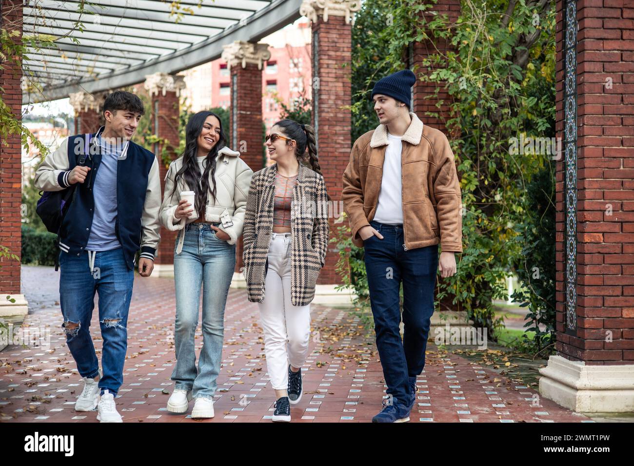 four young university students laughing walking around the campus Stock ...